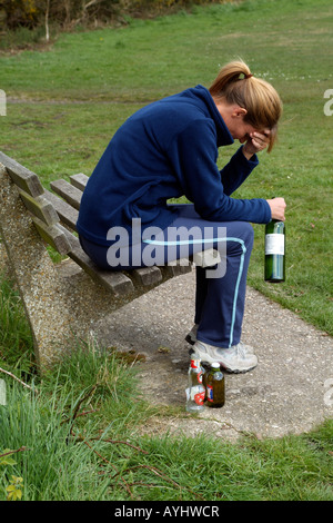 Woman with a alcohol problem Laying on Park Bench with Wine and Beer ...