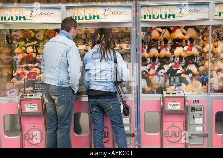 Man playing fairground grab machine filled with cuddly toys Stock Photo ...
