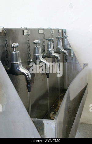 Dripping tap of a water tank in the open . Drops fall from the pipe ...