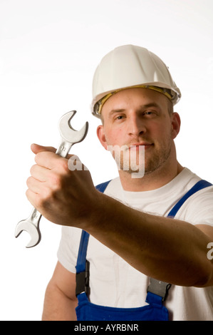 Worker with open-end wrench A man in work clothes takes a wrench to a ...