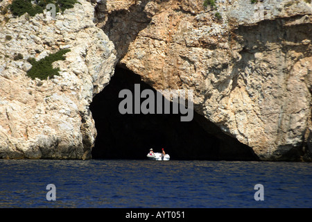 A little boat is aproaching the Blue Cave at Gioura island Alonisos ...
