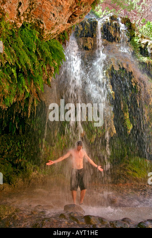 Man under waterfall Stock Photo - Alamy
