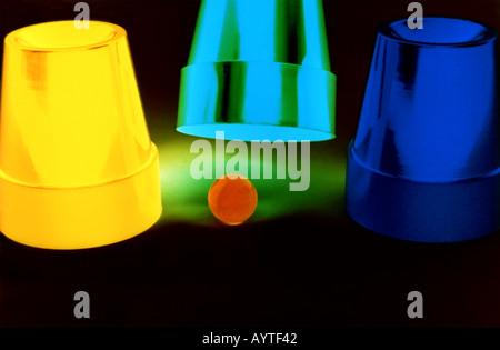 Shell game with three plastic cups and marble Stock Photo - Alamy