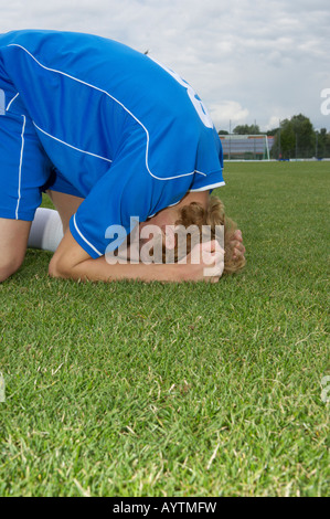 Angry kicker kneeing on soccer field Stock Photo - Alamy