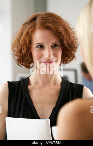 Two young women talking, face to face, drink on the table Stock Photo ...