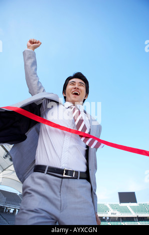 a man entering the finish line with raising her hand Stock Photo - Alamy
