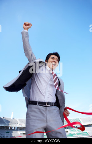 a man entering the finish line with raising her hand Stock Photo - Alamy