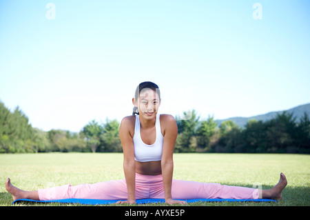a woman excising on grass field Stock Photo - Alamy
