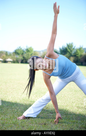 a woman excising on grass field Stock Photo - Alamy
