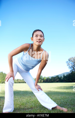 a woman excising on grass field Stock Photo - Alamy