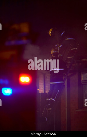 Firefighter on a roof fighting a fire Stock Photo - Alamy