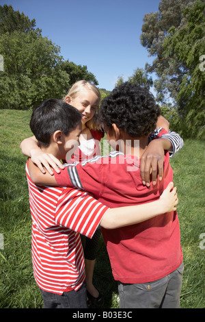 Three Children Huddling Stock Photo - Alamy