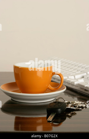 Vertical shot of a cup of coffee, keyboard, and laptop on a wooden desk ...