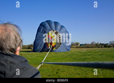 A hot air balloon deflating after landing in a field in Cheshire Stock ...