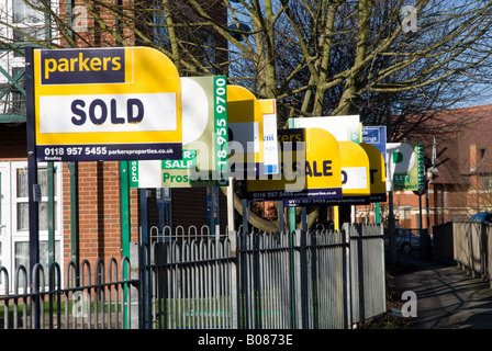 lots of estate agent boards for sale, sold, to let boards all lined up ...