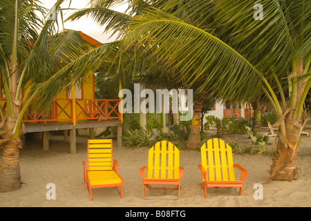 Belize, Placencia, Lounge chairs on tropical beach at sunset Stock ...