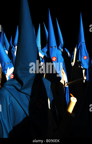 Penitents dressed in penitential robes (nazareno) carrying crosses ...