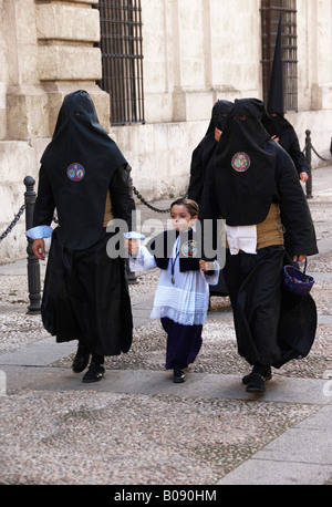 Penitents dressed in penitential robes (nazareno) carrying crosses ...