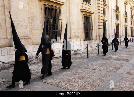 Penitents dressed in black penitential robes (nazareno) on their way to ...