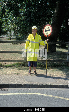 Lollypop lady holding a stop sign board and smiling, London, England ...