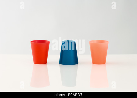 Three colored cups, upside down Stock Photo - Alamy