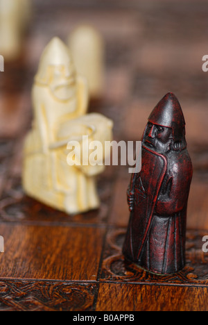 A replica set of the Lewis chess men, on board lit by candlelight Stock ...