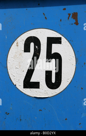 Number 25 sign with black figures in white circle on blue background ...