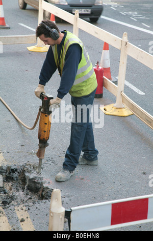 Road worker digging up tarmac Stock Photo - Alamy