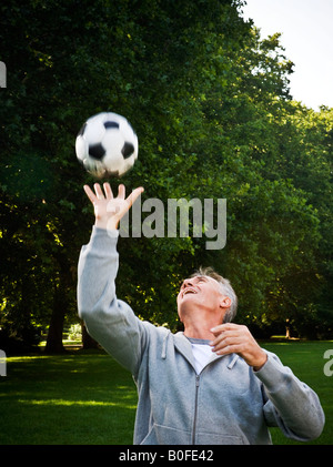 Senior man catching soccer ball Stock Photo - Alamy