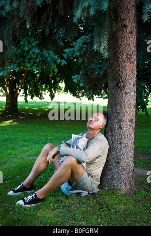 Man sleeping under a tree Stock Photo - Alamy