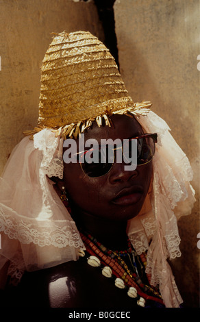 A Voodoo believer in ritual clothing at a temple ceremony, Ouidah ...