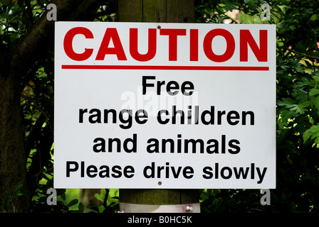 A caution free range children and animals, please drive slowly sign ...