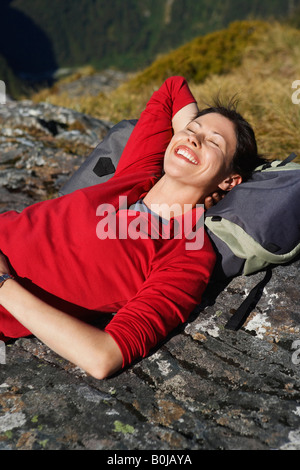 Woman resting on boulders on a backpack trip in Oregon's Wallowa ...