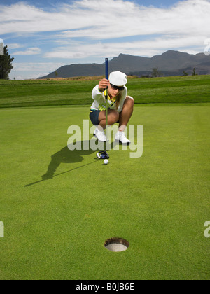 Golfer lining up putt Stock Photo - Alamy