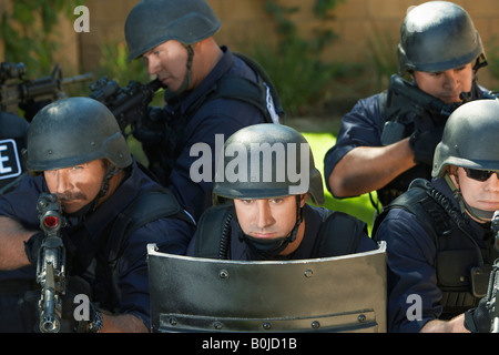 Swat officers behind shield Stock Photo - Alamy