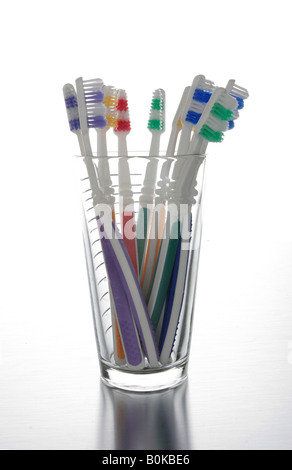 Colorful Toothbrushes in glass on blue wood background. Dental and oral ...