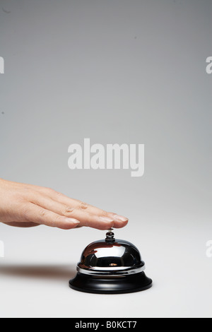 Person's Hand on Desk Bell Stock Photo - Alamy