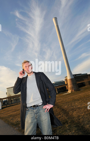 Young swedish man calling with a cell phone in front of the Ericsson ...