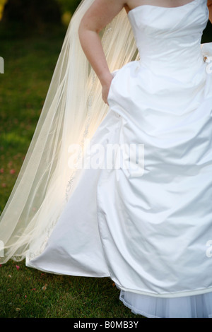 A bride in a white gown and veil entering a portable toilet Stock Photo ...