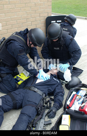 Police firearms officers giving medical assistance to injured officer ...