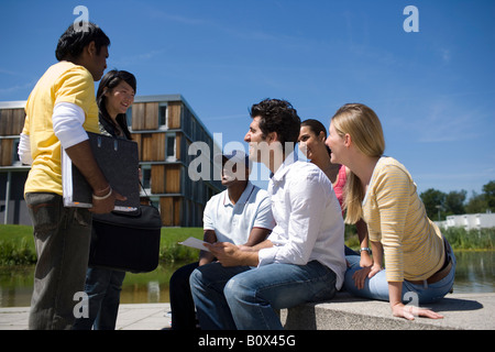 Three students talking or socializing at university campus - Friends ...