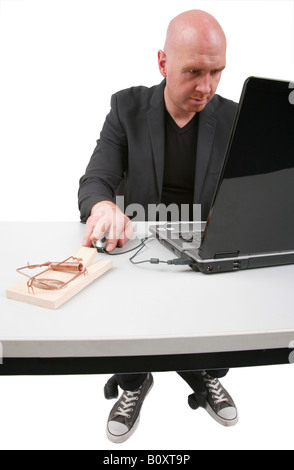 young bald headed man working at his writing desk is holding a computer ...