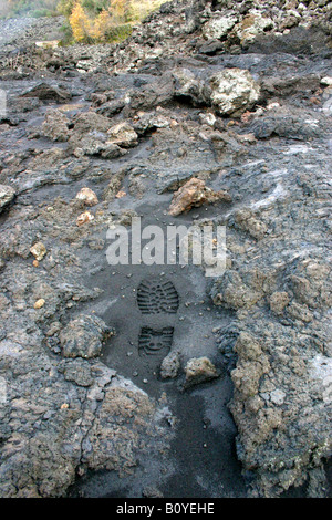 Footprints in ash of the volcanic landscape of Mount Etna with black ...