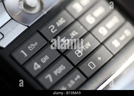 Close up shot of a mobile phone with broken screen on a wooden table ...