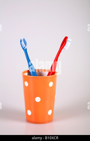Toothbrush red and blue in a spotted holder Stock Photo - Alamy