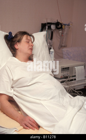 young woman in labour in hospital accompanied by partner and mother ...