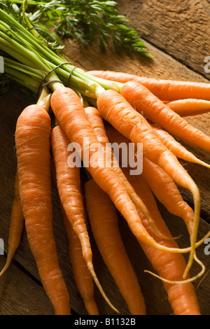 Bunch of fresh carrot on wooden table Stock Photo - Alamy