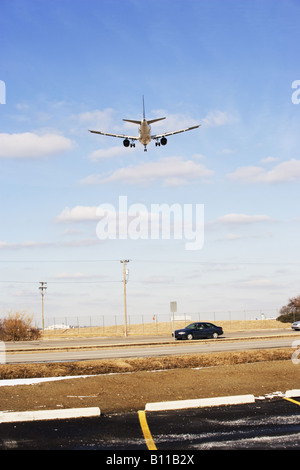 Airplane flying over highway preparing to land at airport Stock Photo ...