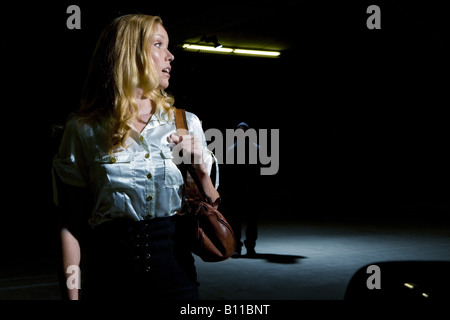 Woman approaches car and sees prowler in background Stock Photo - Alamy
