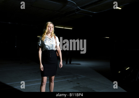 Woman approaches car and senses prowler in background Stock Photo - Alamy